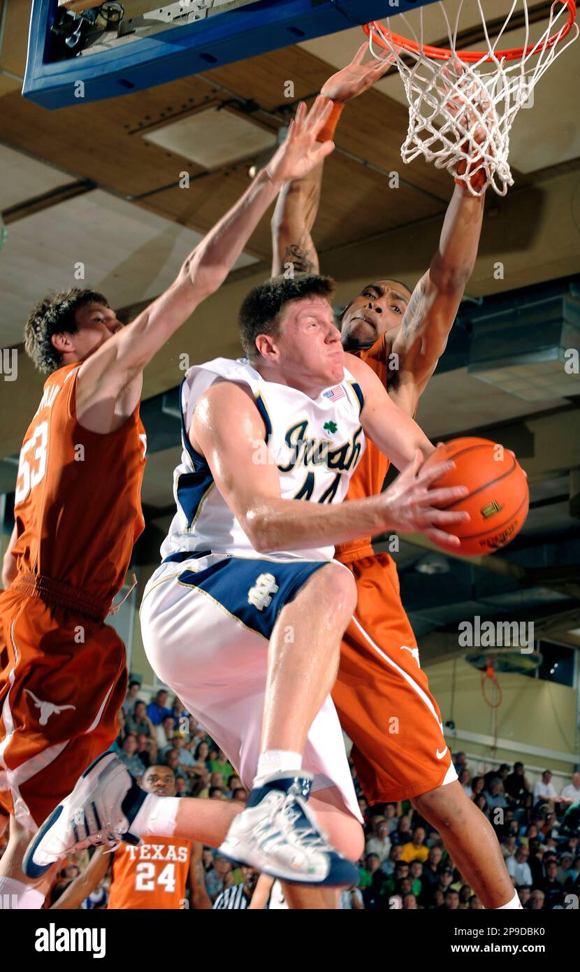 Notre Dame's Luke Harangody drives between Texas' Clint Chapman, left ...