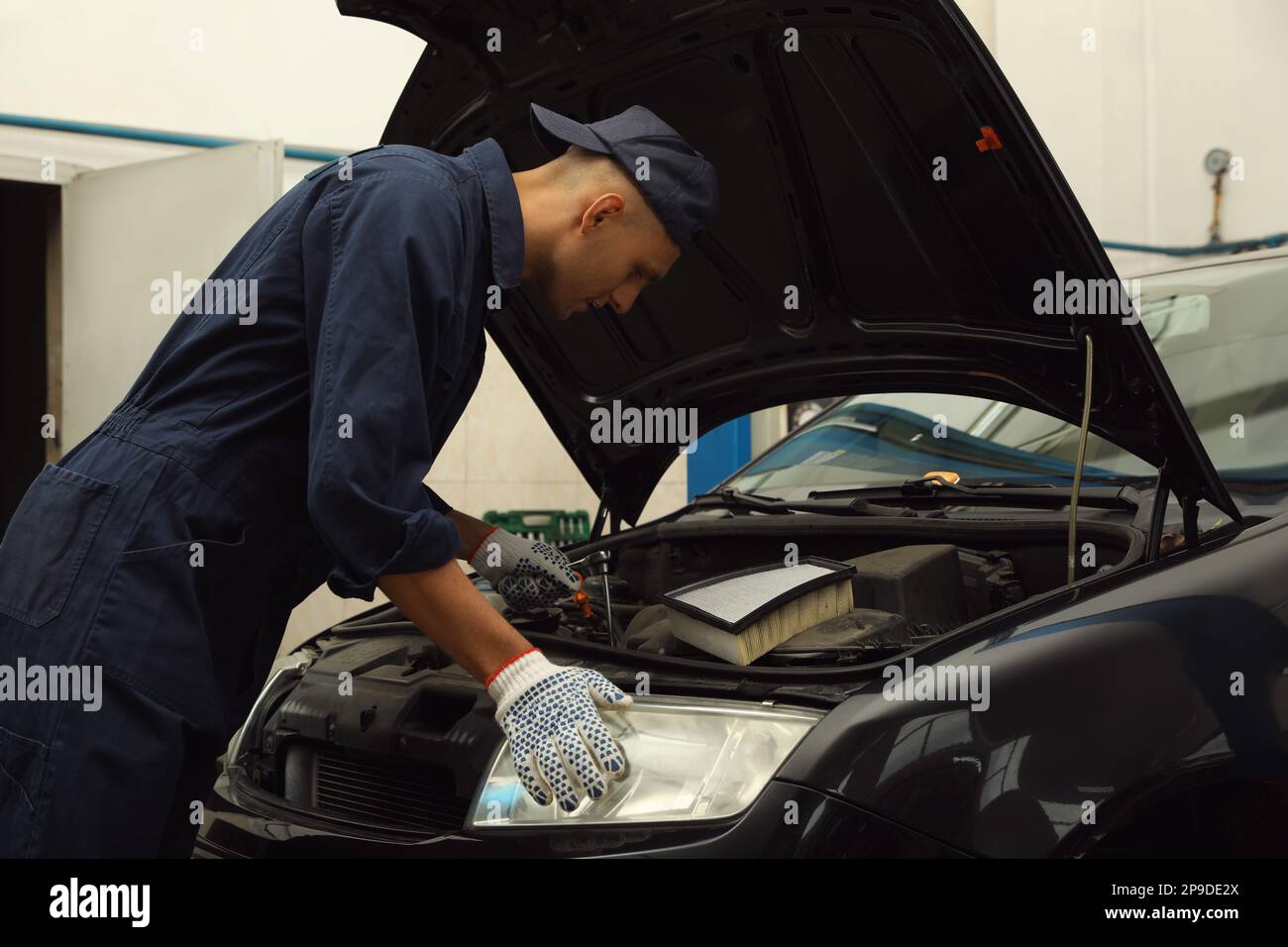 Professional mechanic fixing modern car at automobile repair shop Stock ...