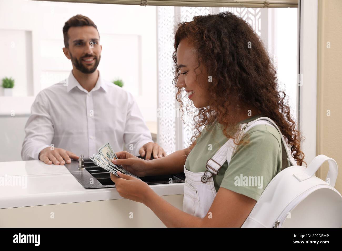 African American woman with money at cash department window in bank ...