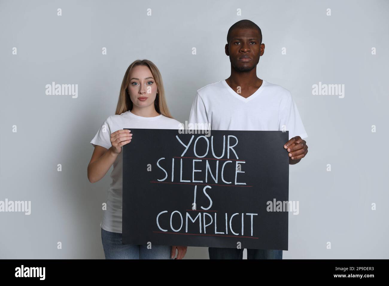 Young woman and African American man holding sign with phrase Your ...