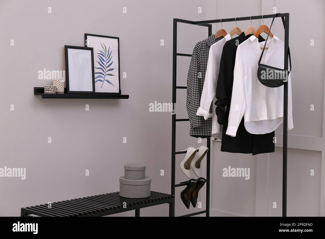 Rack with stylish women's clothes and bench in dressing room Stock ...
