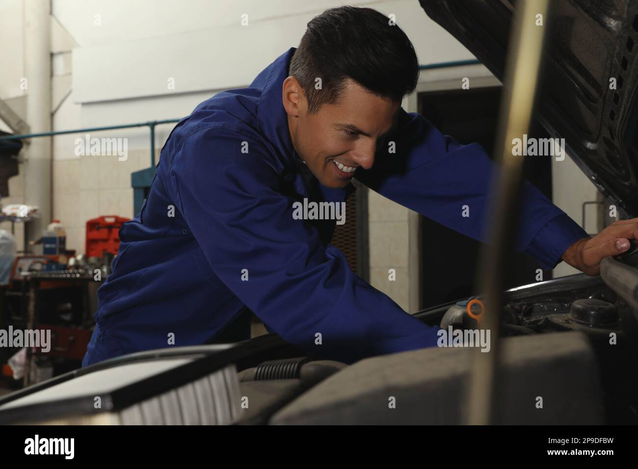 Professional mechanic fixing modern car at automobile repair shop Stock ...