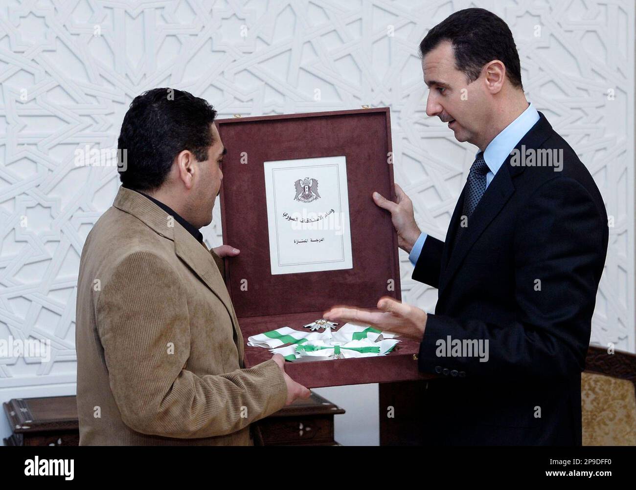 Syrian President Bashar Assad, right, presents the Syrian Order of ...