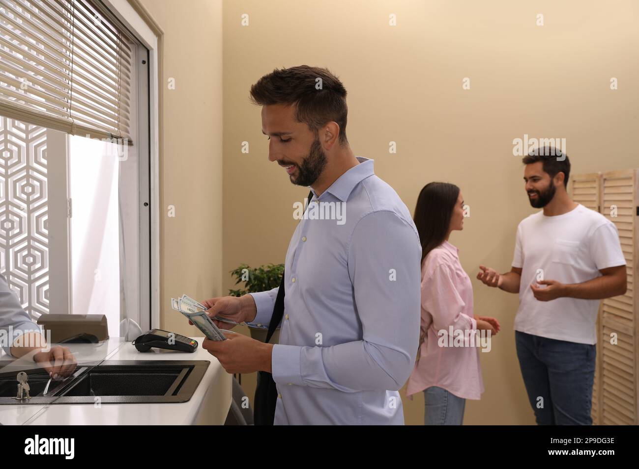 Man with money at cash department window in bank. Currency exchange ...