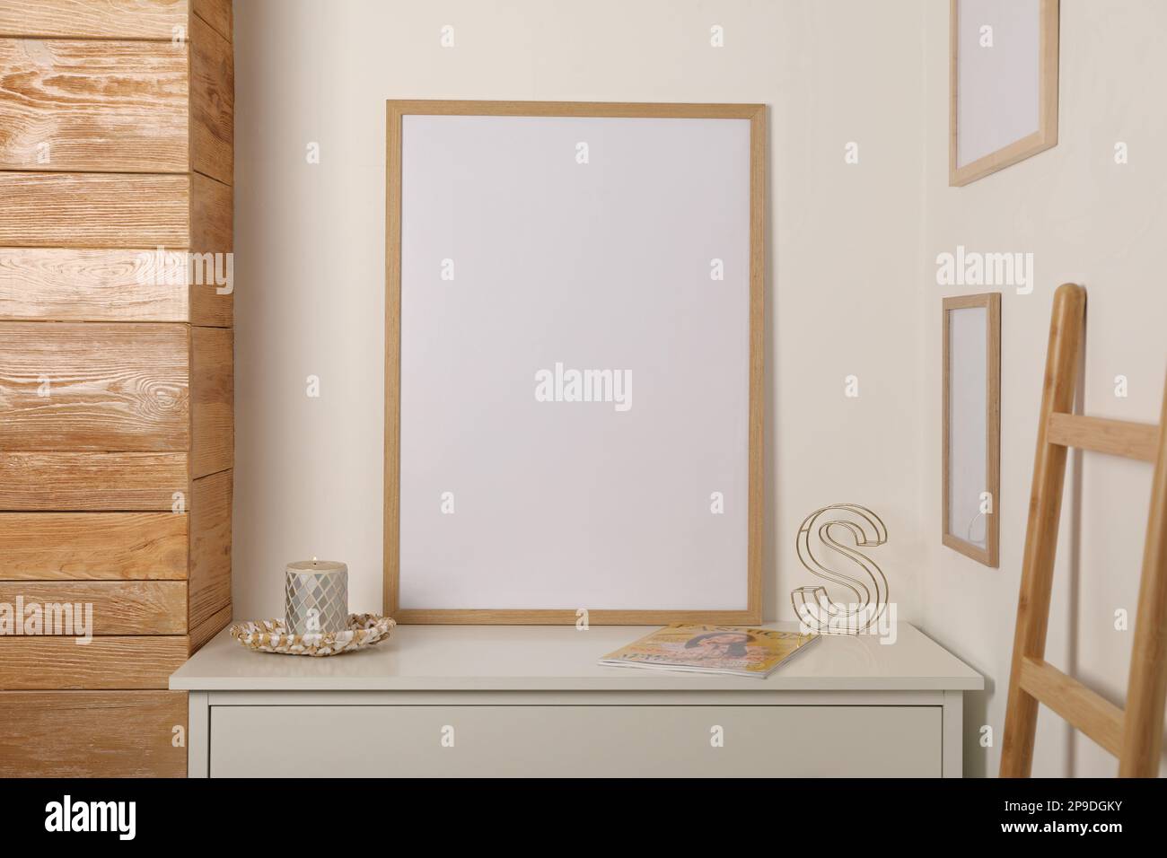 Blank frame on chest of drawers and decor indoors. Space for design ...