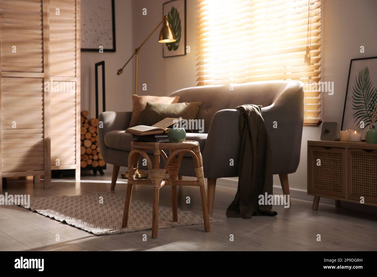 Stylish living room interior with stool and sofa Stock Photo - Alamy