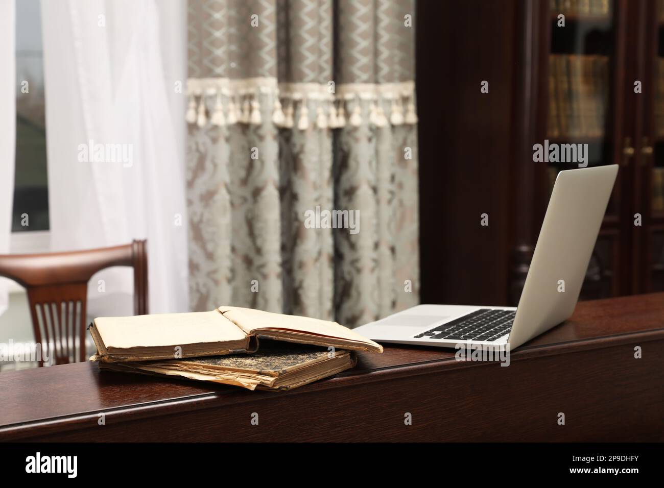 Old books and laptop on wooden table in library reading room Stock ...