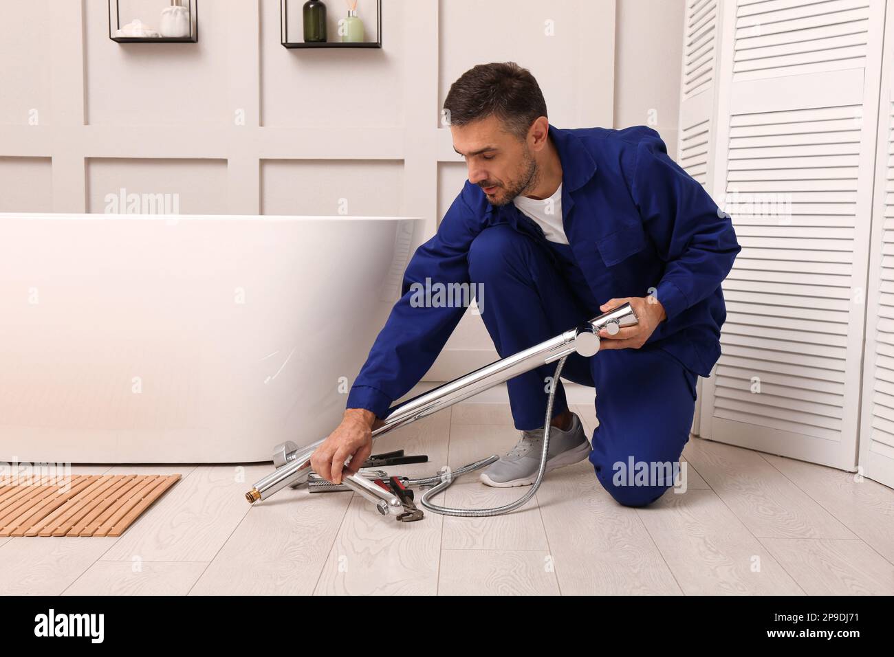 Professional plumber installing water tap in bathroom Stock Photo - Alamy