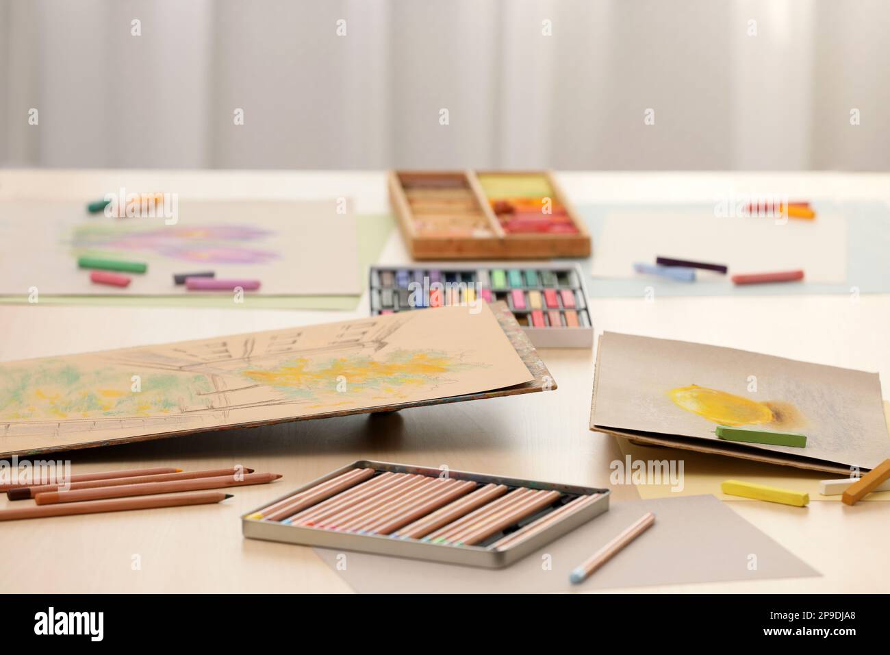 Artist's workplace with drawings, soft pastels and color pencils on ...