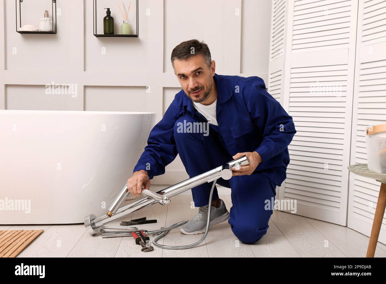 Professional plumber installing water tap in bathroom Stock Photo - Alamy