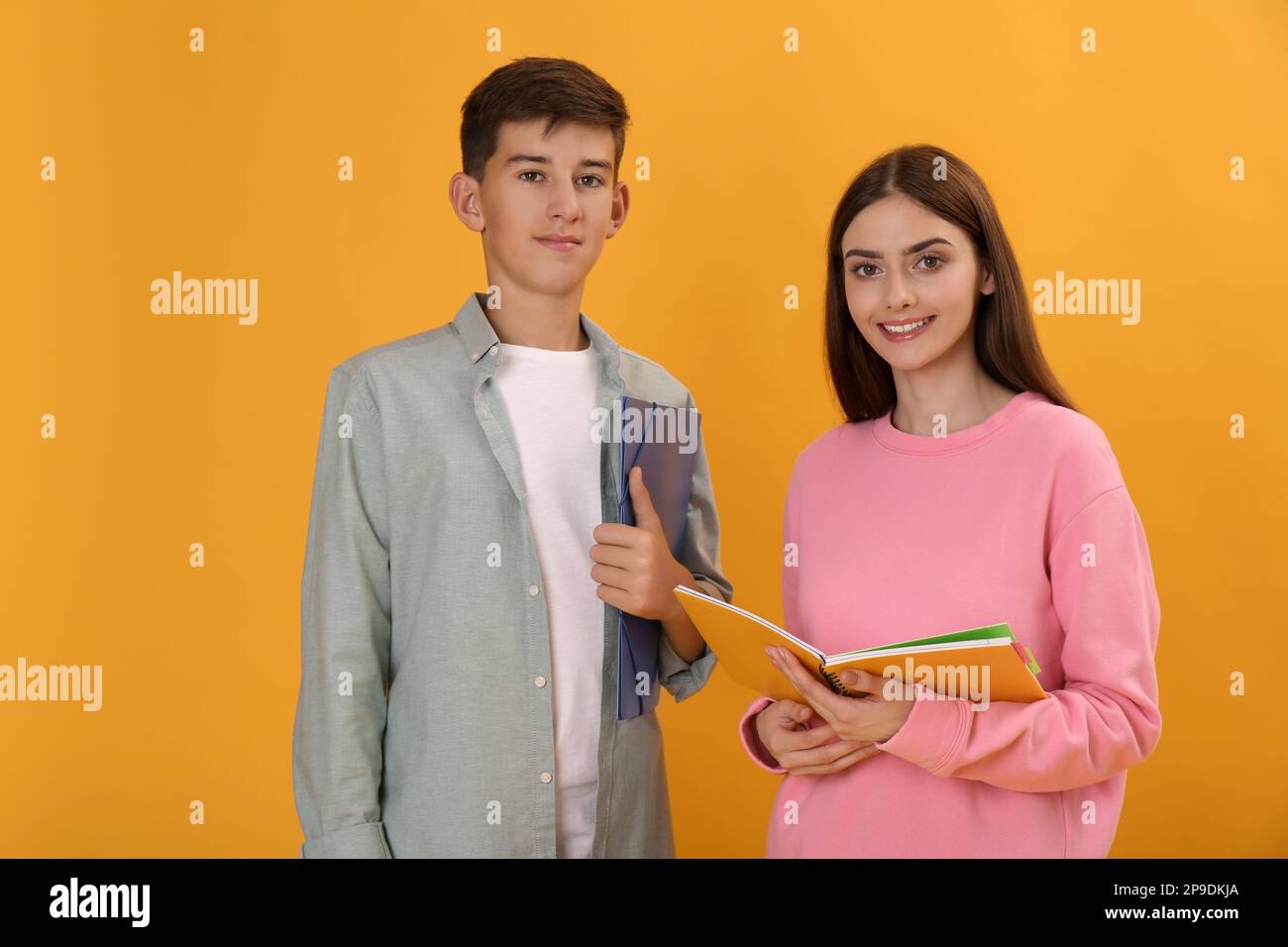 Teenage students with stationery on yellow background Stock Photo - Alamy