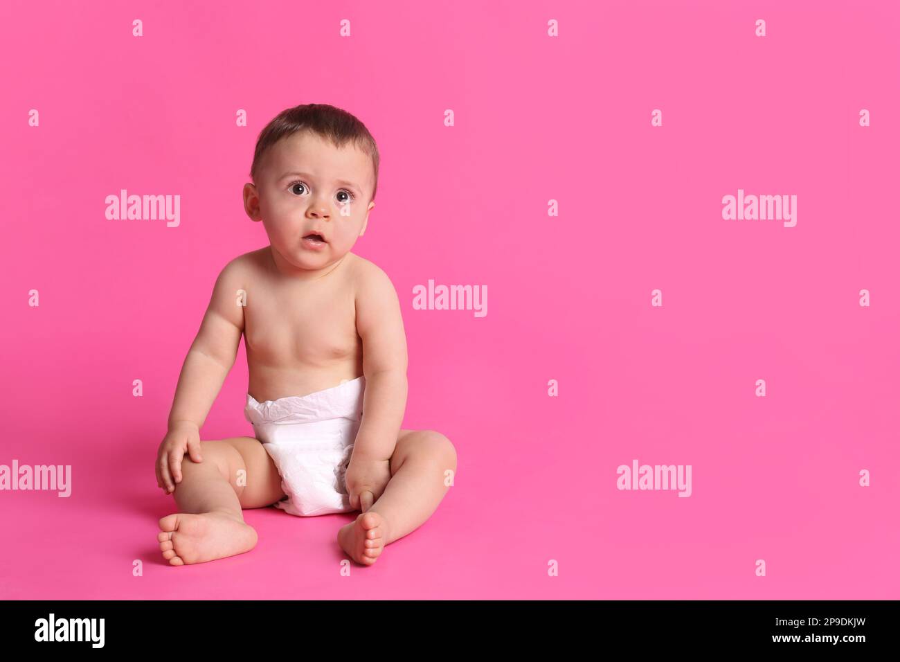 Cute baby in dry soft diaper sitting on pink background. Space for text ...