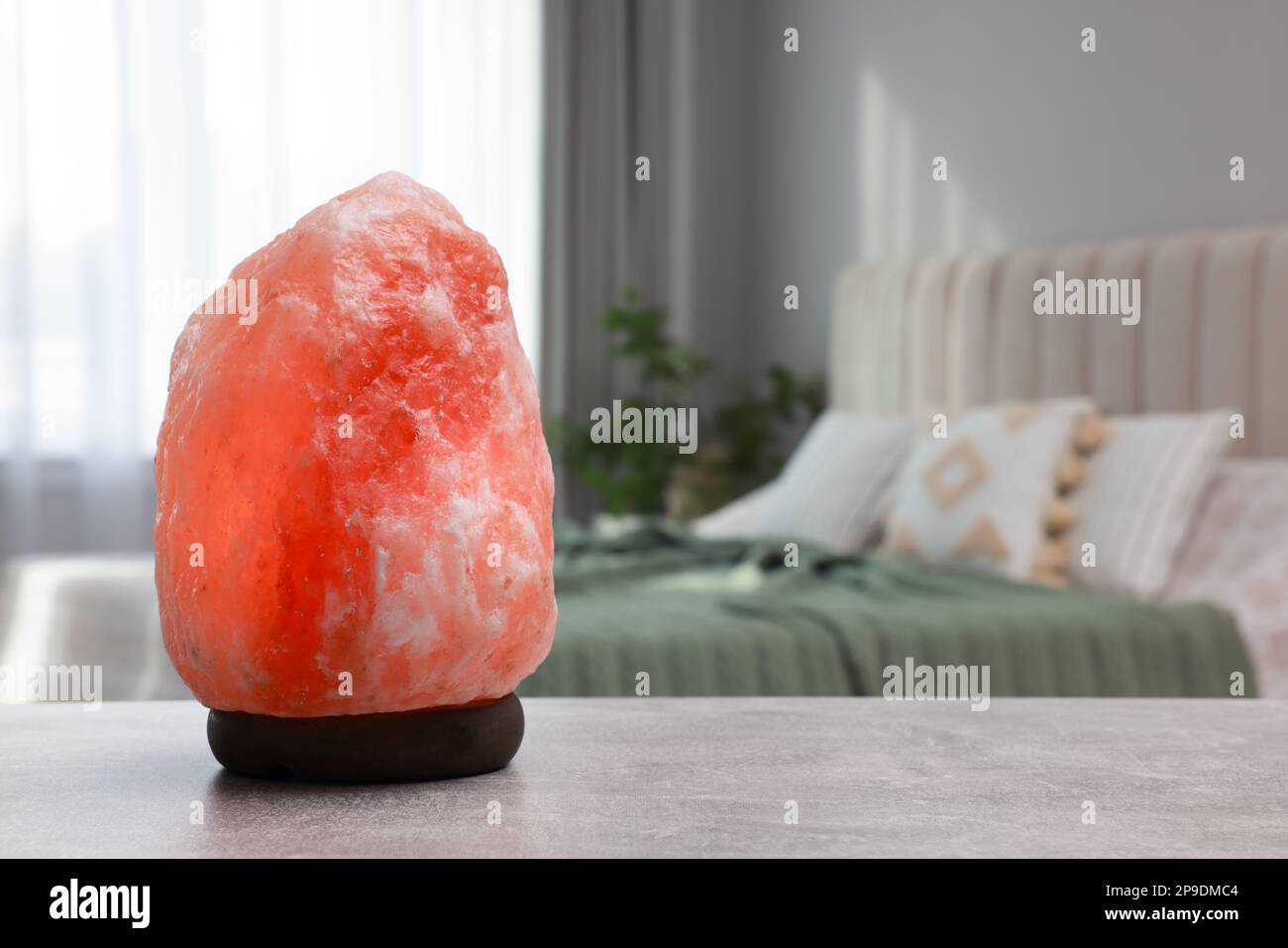 Beautiful Himalayan salt lamp on light grey table in bedroom, space for ...