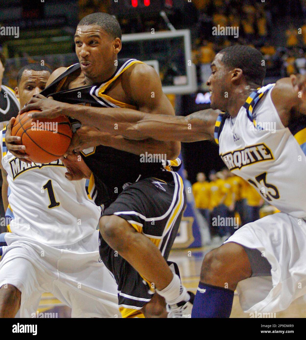 Wisconsin-Milwaukee's Avery Smith, center, fights off the defense of ...