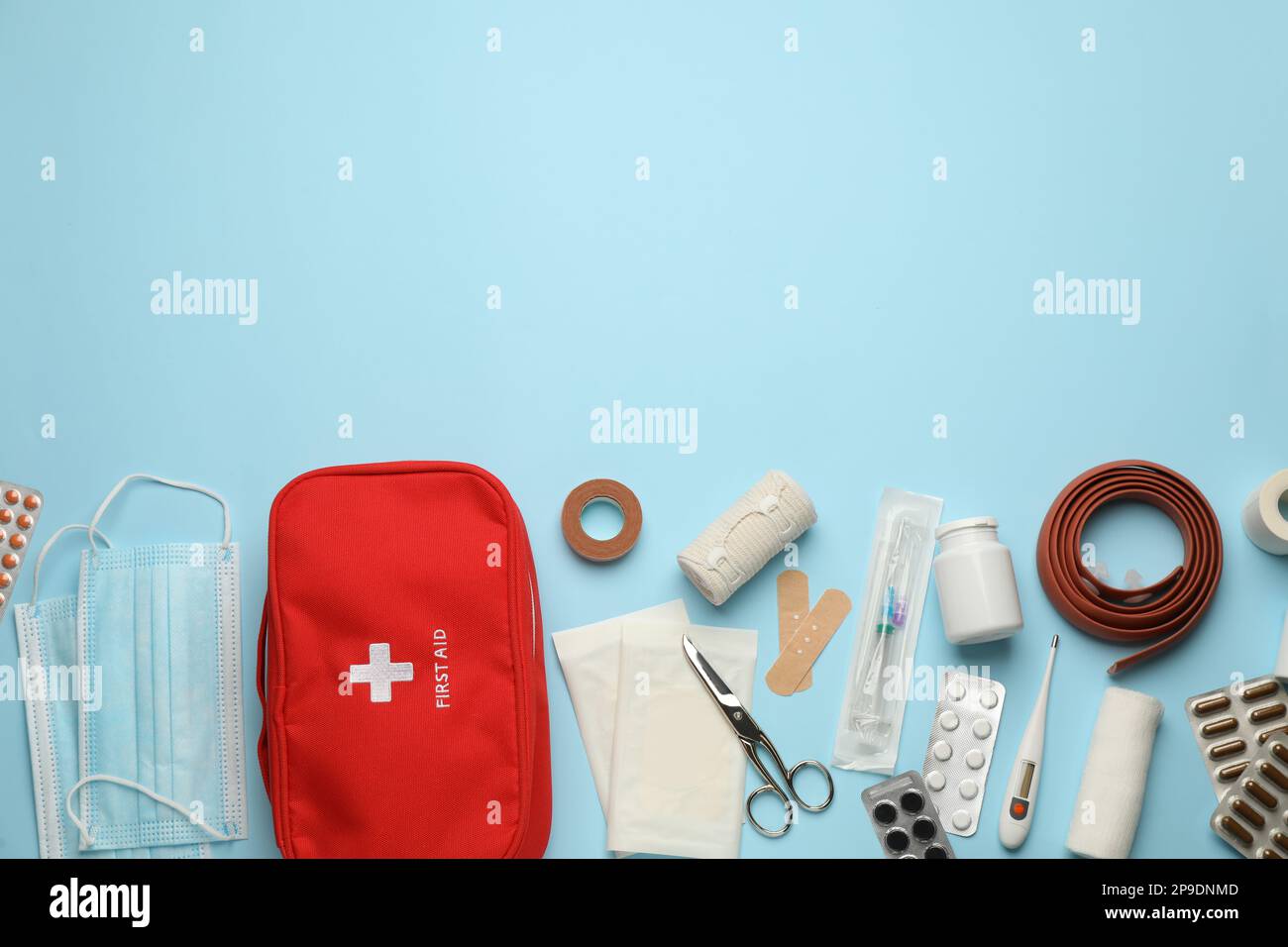 Flat lay composition with first aid kit on light blue background, space ...