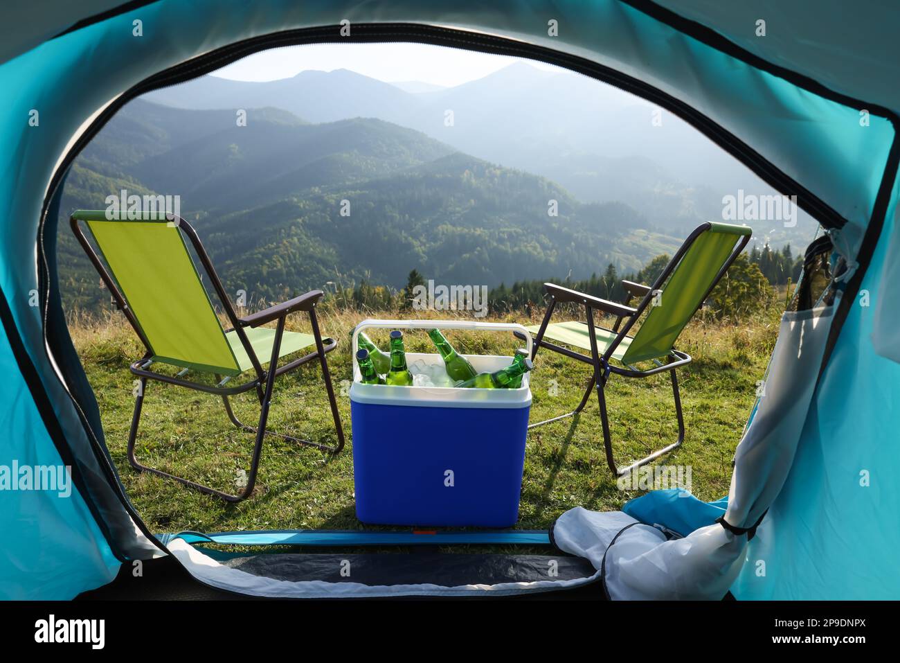 Chairs and cool box with bottles of beer in mountains, view from tent ...