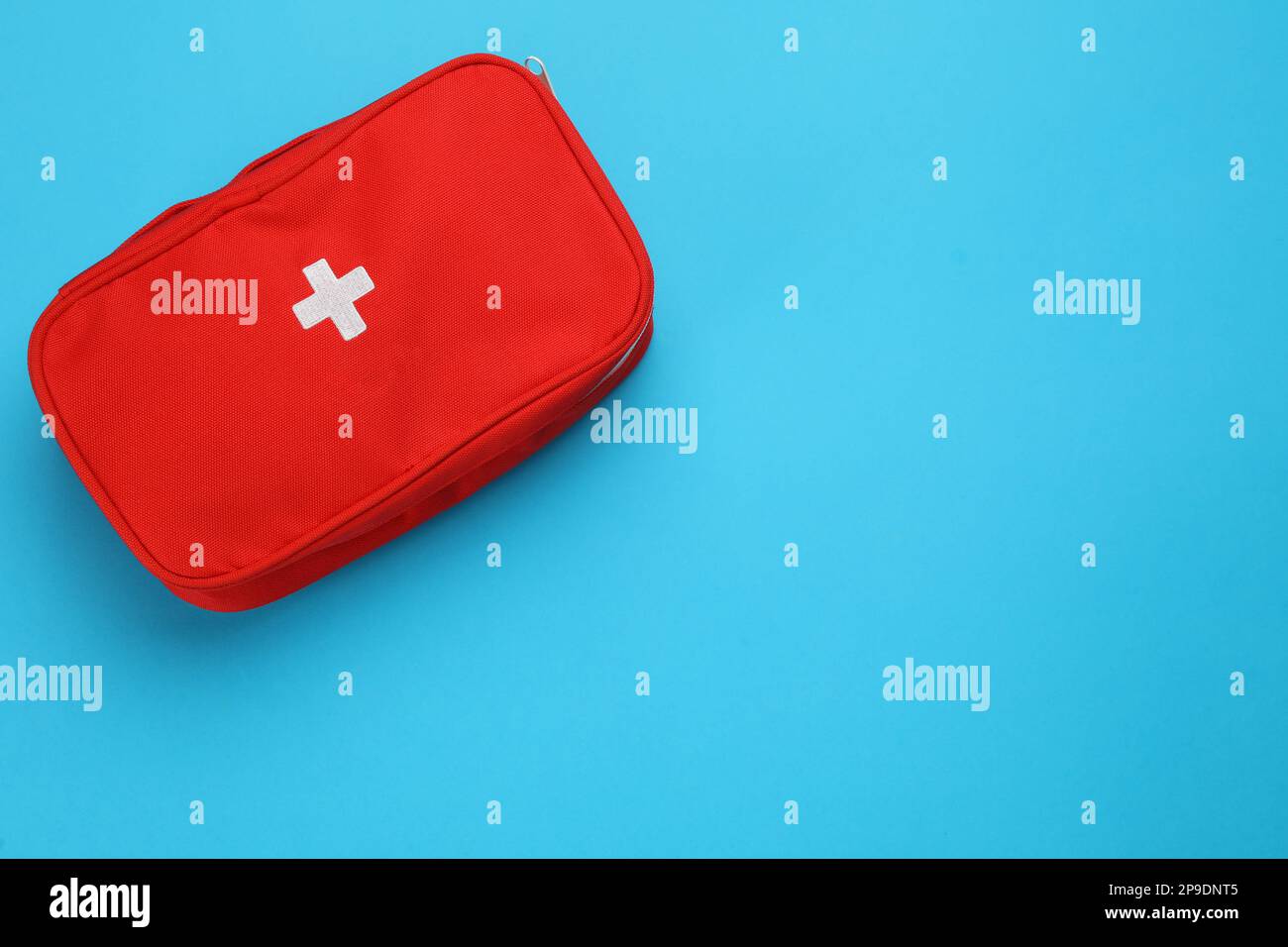 First aid kit bag on light blue background, top view. Space for text ...