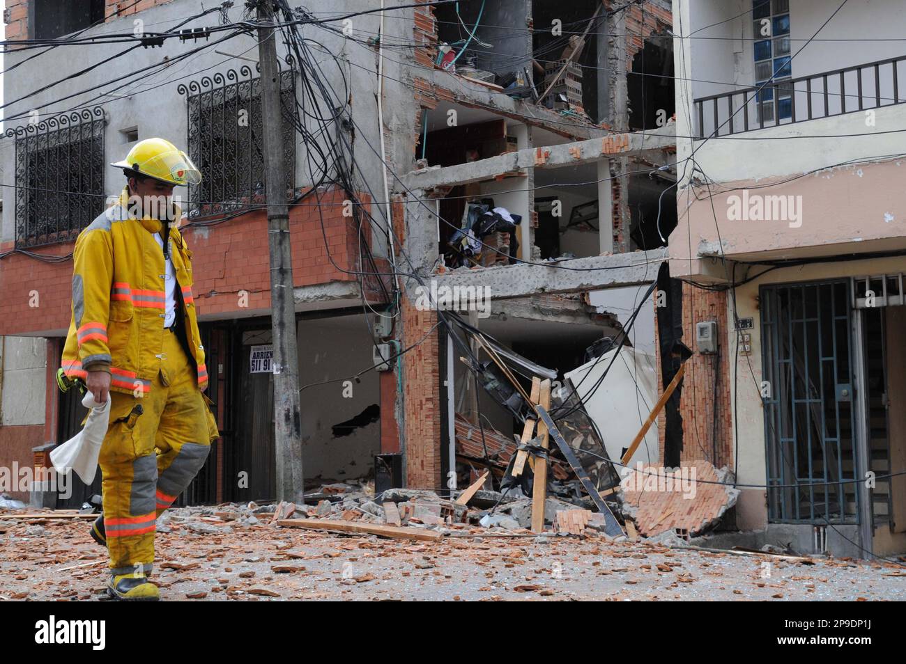 A fire fighter walks pass a building damaged when a gas cylinder ...