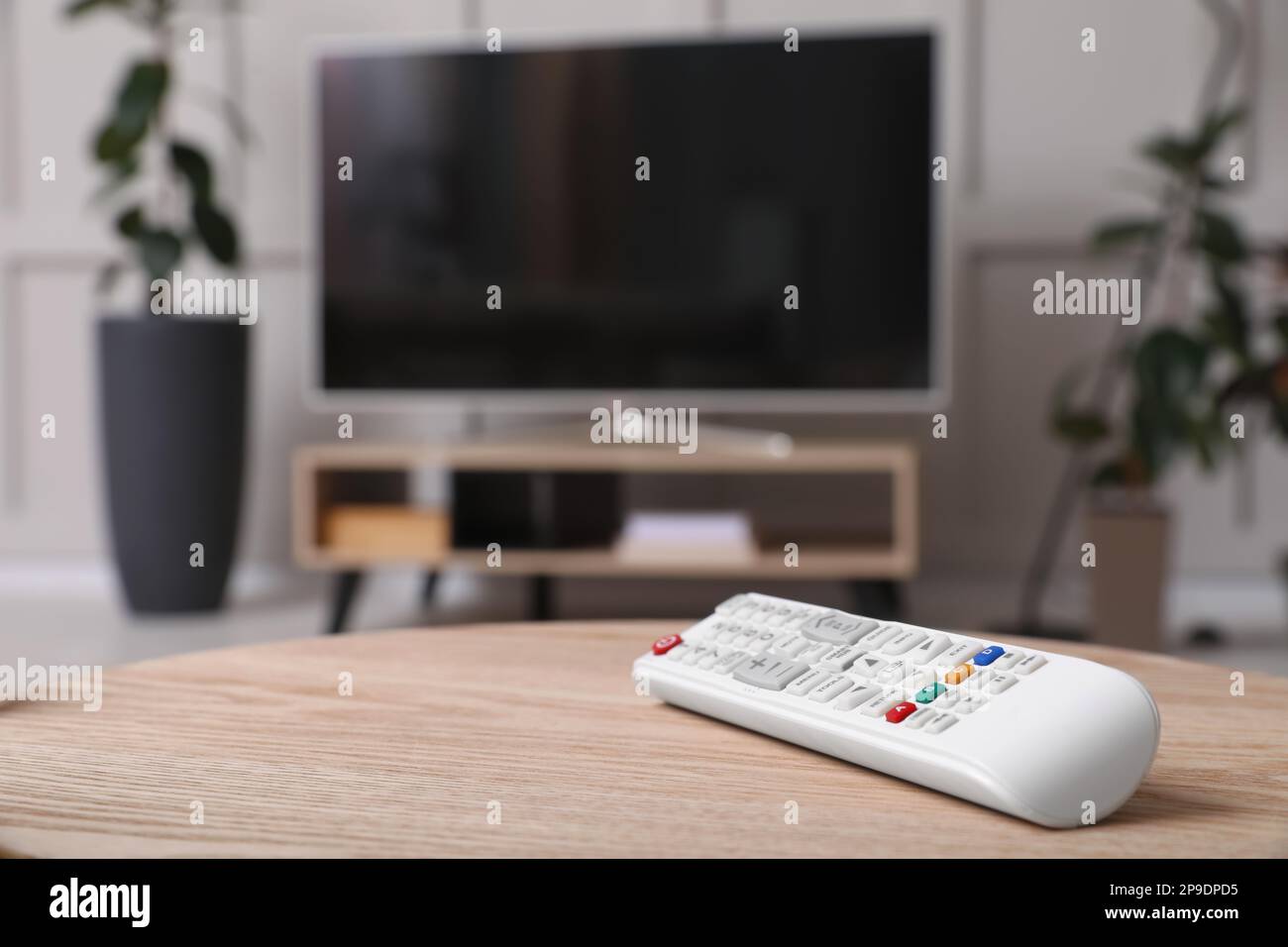 Wooden cabinet with modern TV indoors, focus on remote control Stock ...