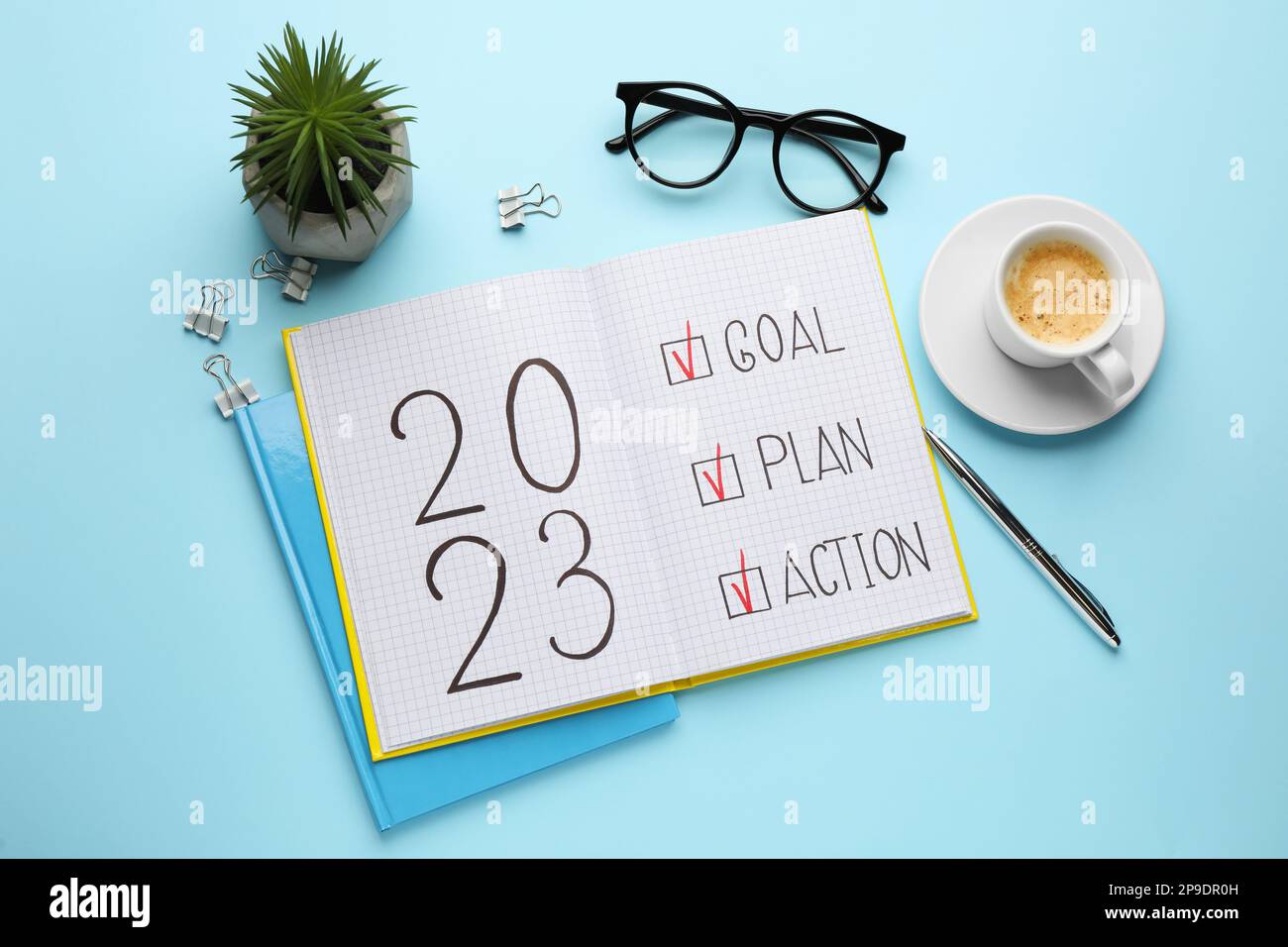 Flat lay composition of notebook with text 2023 Goal, Plan, Action on light blue background. New ...