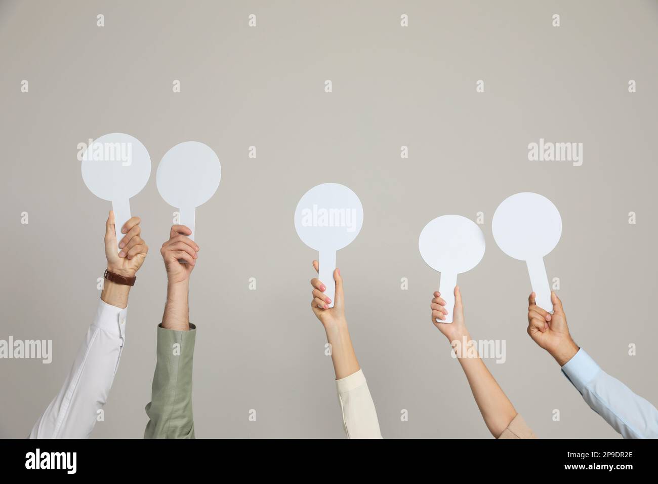 Panel of judges holding blank score signs on beige background, closeup ...