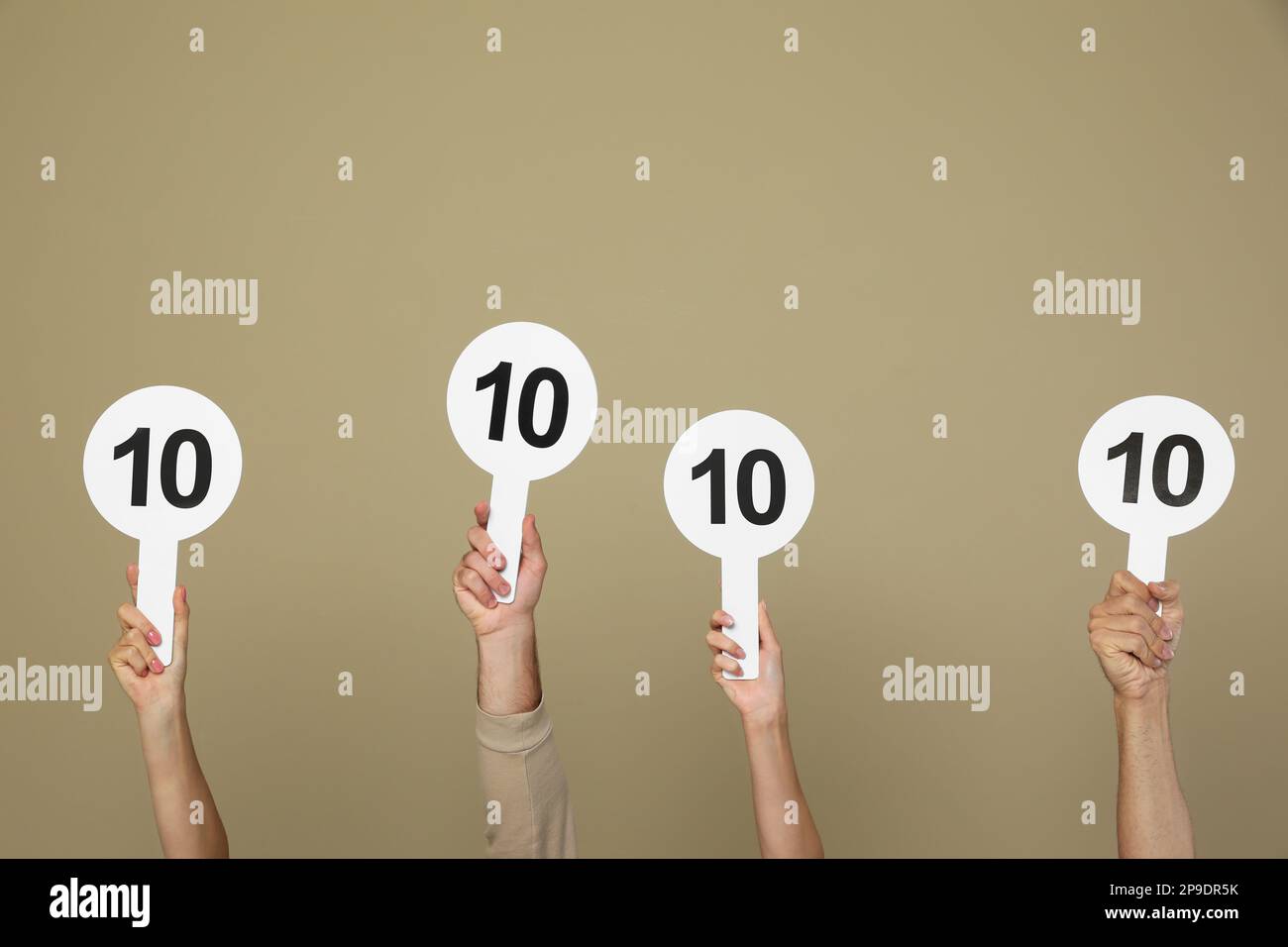 Panel of judges holding signs with highest score on beige background ...