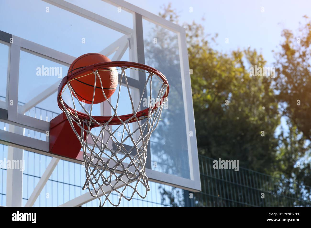 Basketball ball and hoop with net outdoors on sunny day Stock Photo - Alamy
