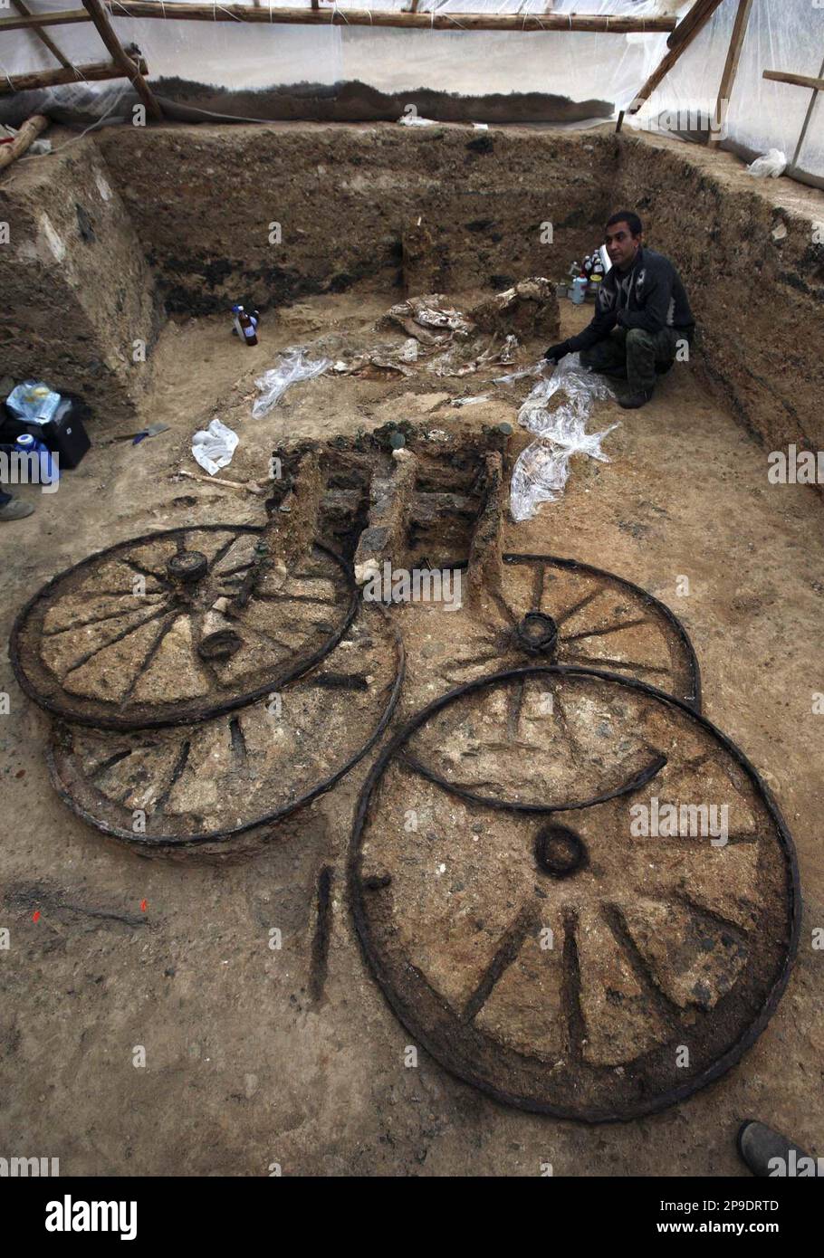 An archaeologist works around a 1,800-year-old bronze chariot at an ...