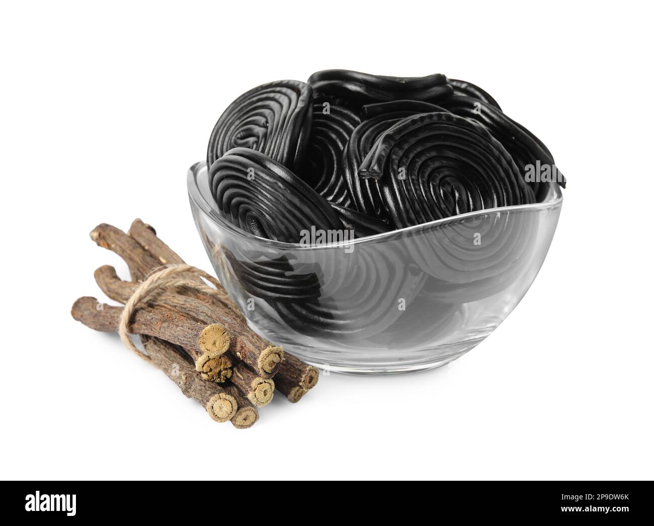 Tasty black candies and dried sticks of liquorice root on white ...
