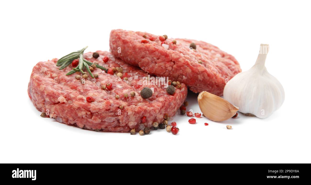 Raw hamburger patties with rosemary, garlic and spices on white ...