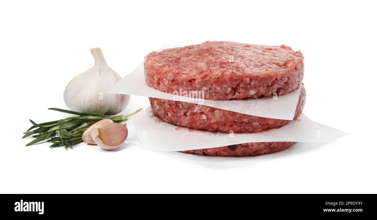 Raw hamburger patties with rosemary and garlic on white background ...