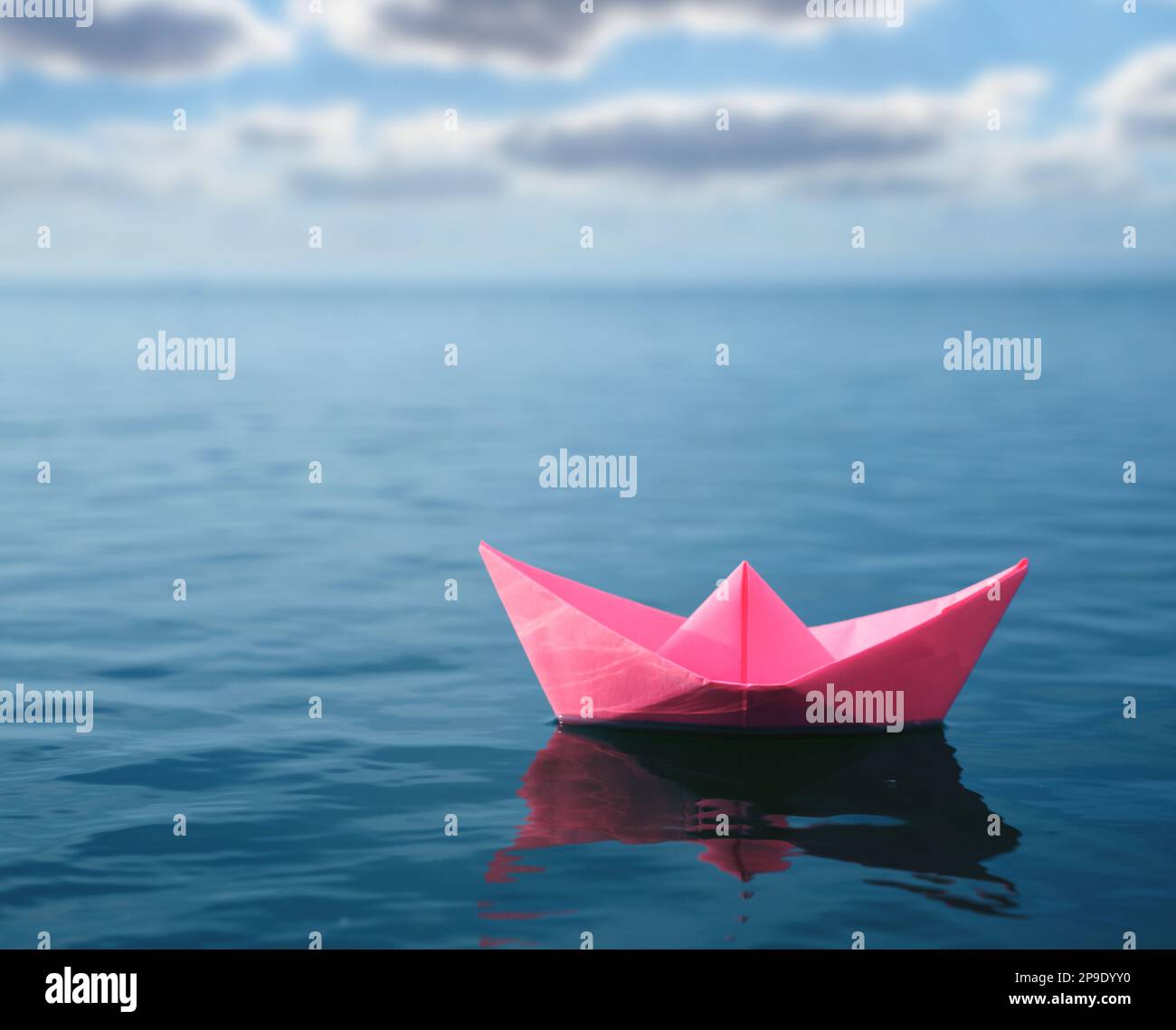 Pink paper boat floating on calm sea Stock Photo - Alamy