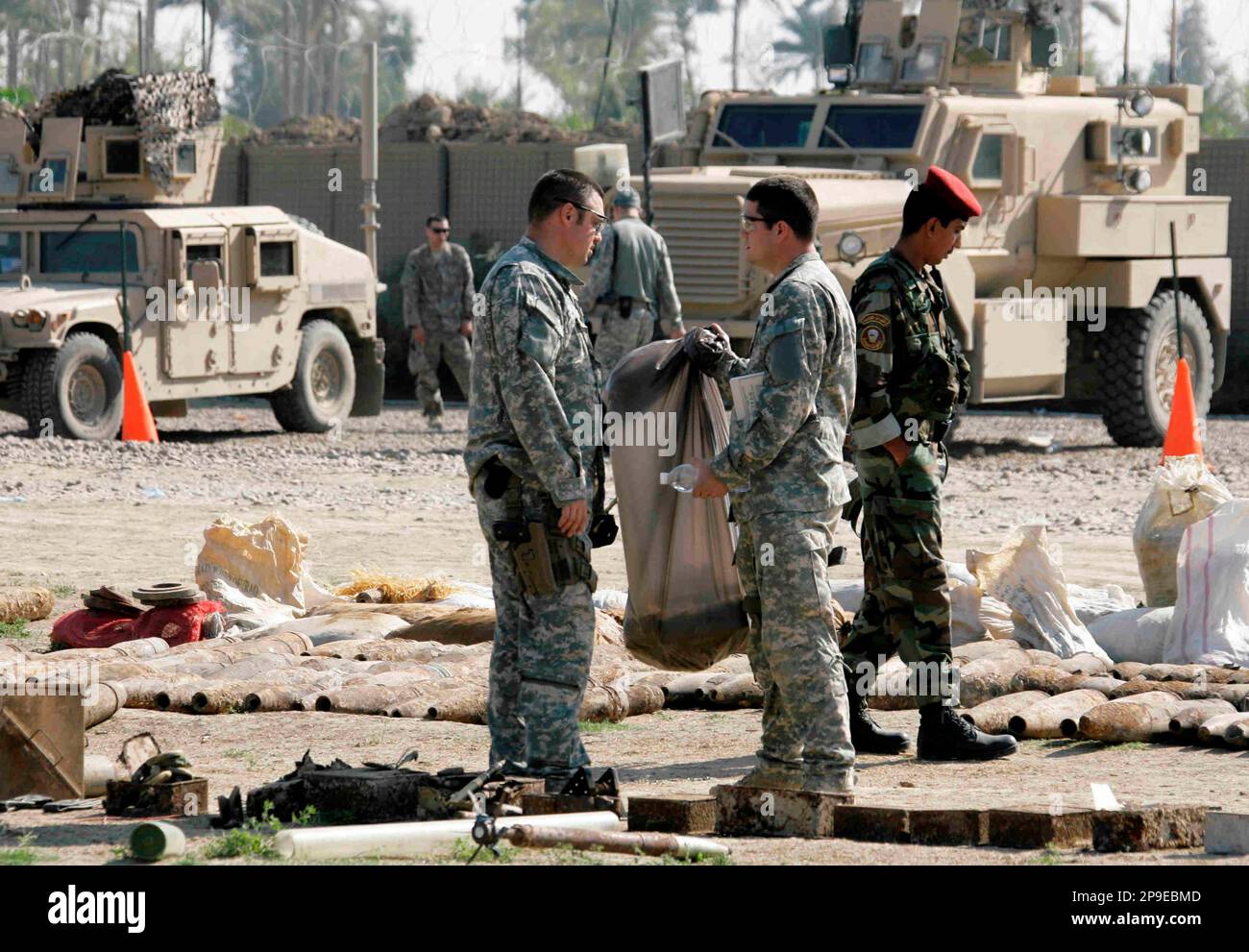A U.S. Army Explosive Ordinance Disposal (EOD) team inspects weapons ...