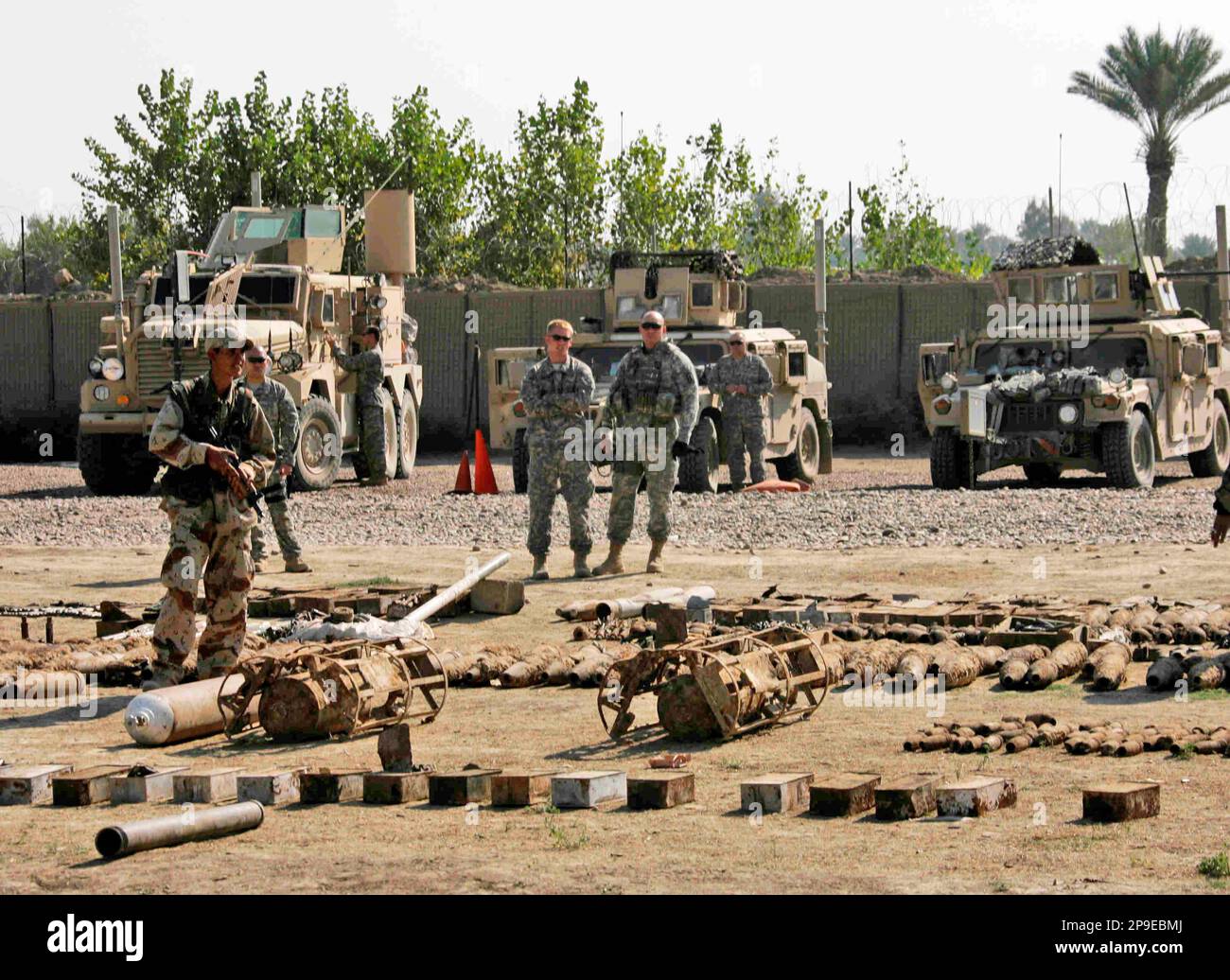 A U.S. Army Explosive Ordinance Disposal (EOD) team inspects weapons ...