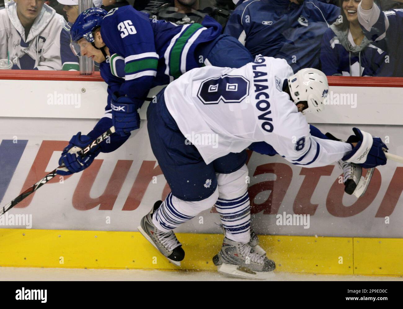 Vancouver Canucks' Jannik Hansen, left, of Denmark, is checked by ...