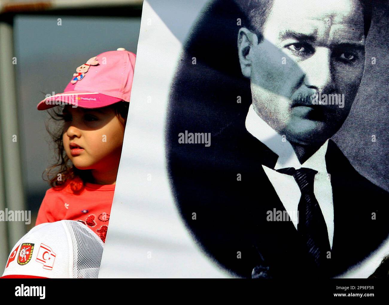 A girl stand by a portrait of the Turkish Republic founder Kemal ...