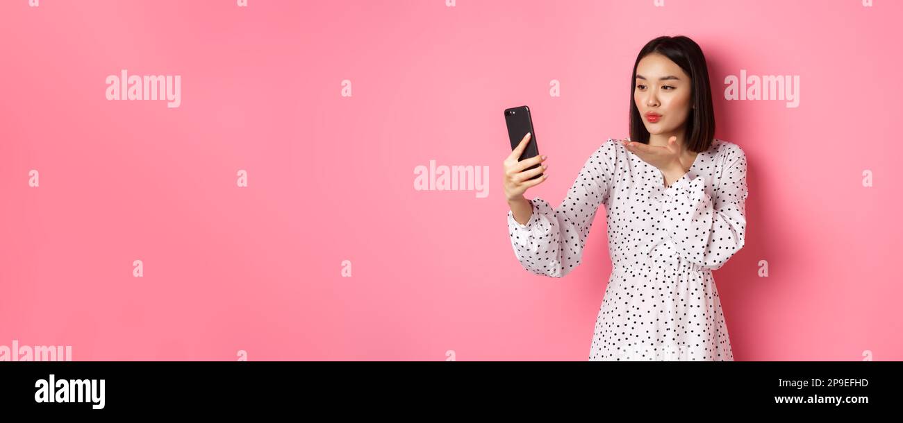 Beautiful asian girl using photo filters app and taking selfie on ...