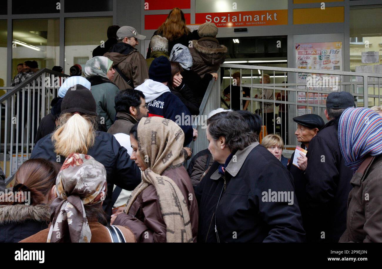 People line up in front of a super market for needy people as they wait ...