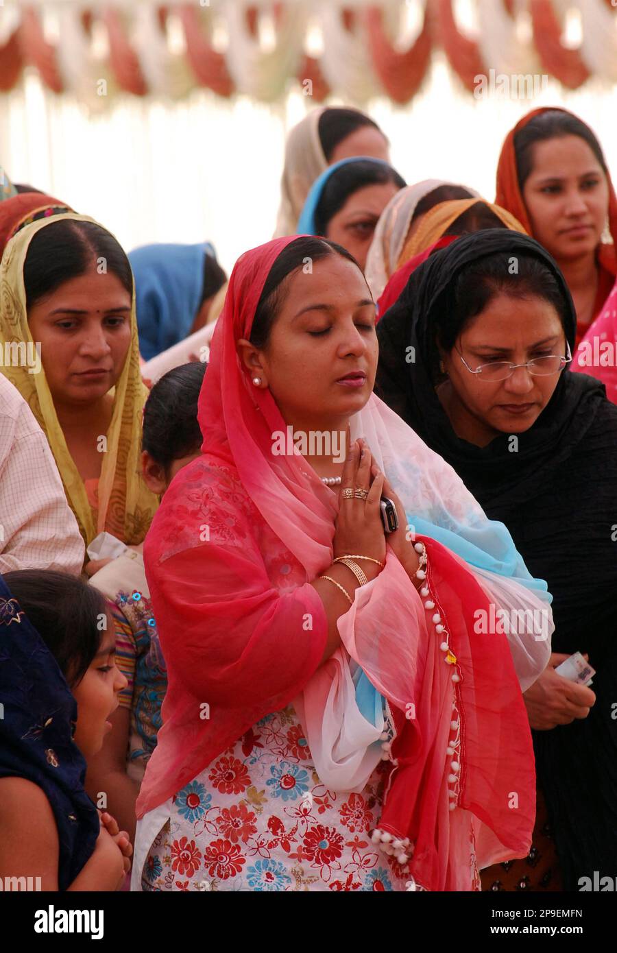 Sikh devotees offer prayers during a religious congregation to mark the ...