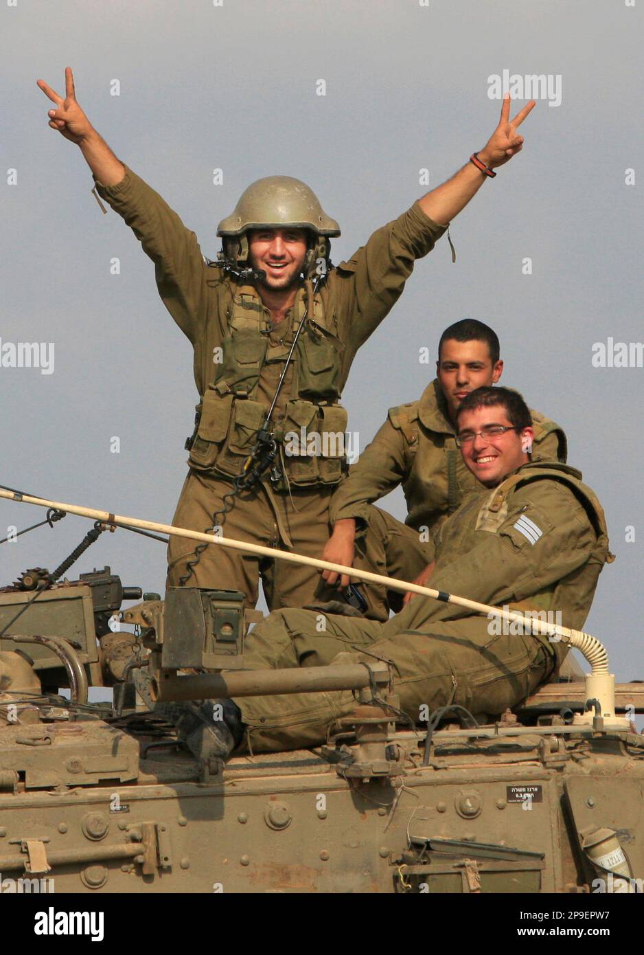 An Israeli tank crew member gestures to photographers on the Israel ...