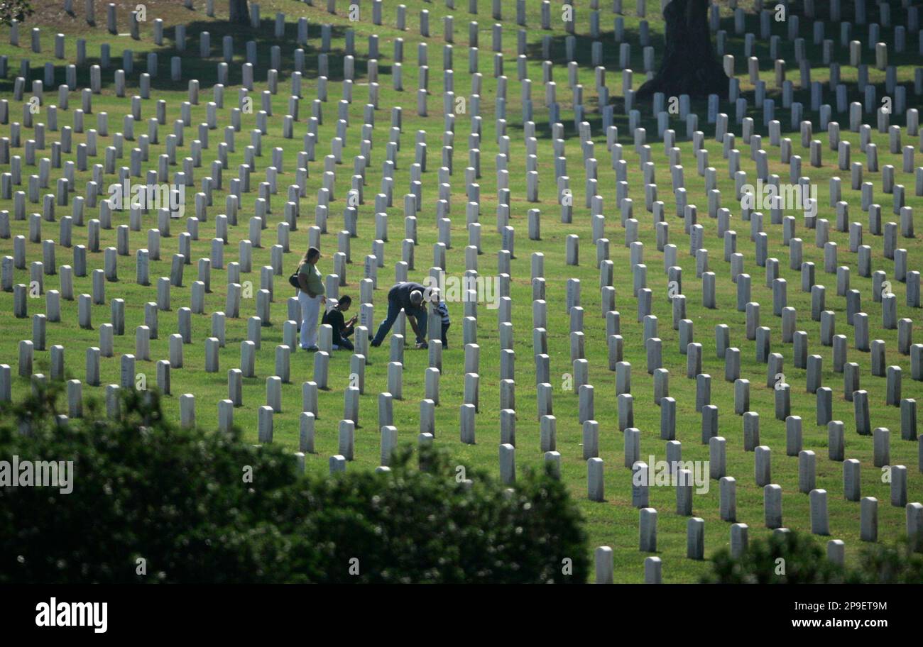 A family visits the grave of a veteran at the Cabrillo National ...