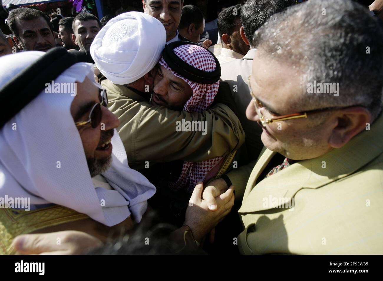 Iraqi Sunnis, left, and Shiites, right, meet in the middle of the Imams ...