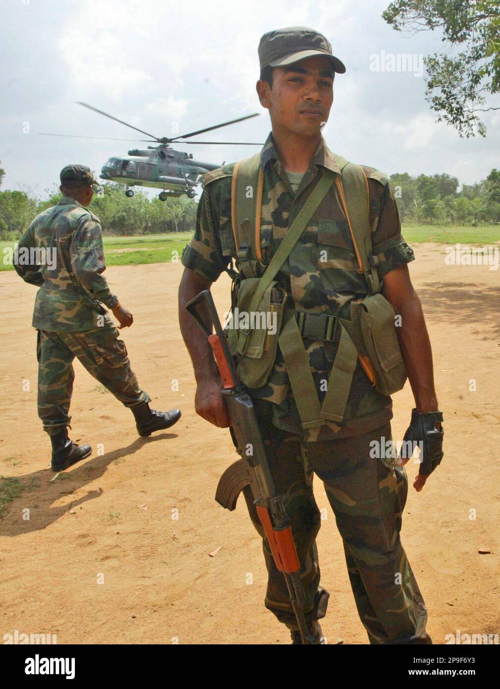 Sri Lankan army soldiers stand guard, as a military choppers lands at ...