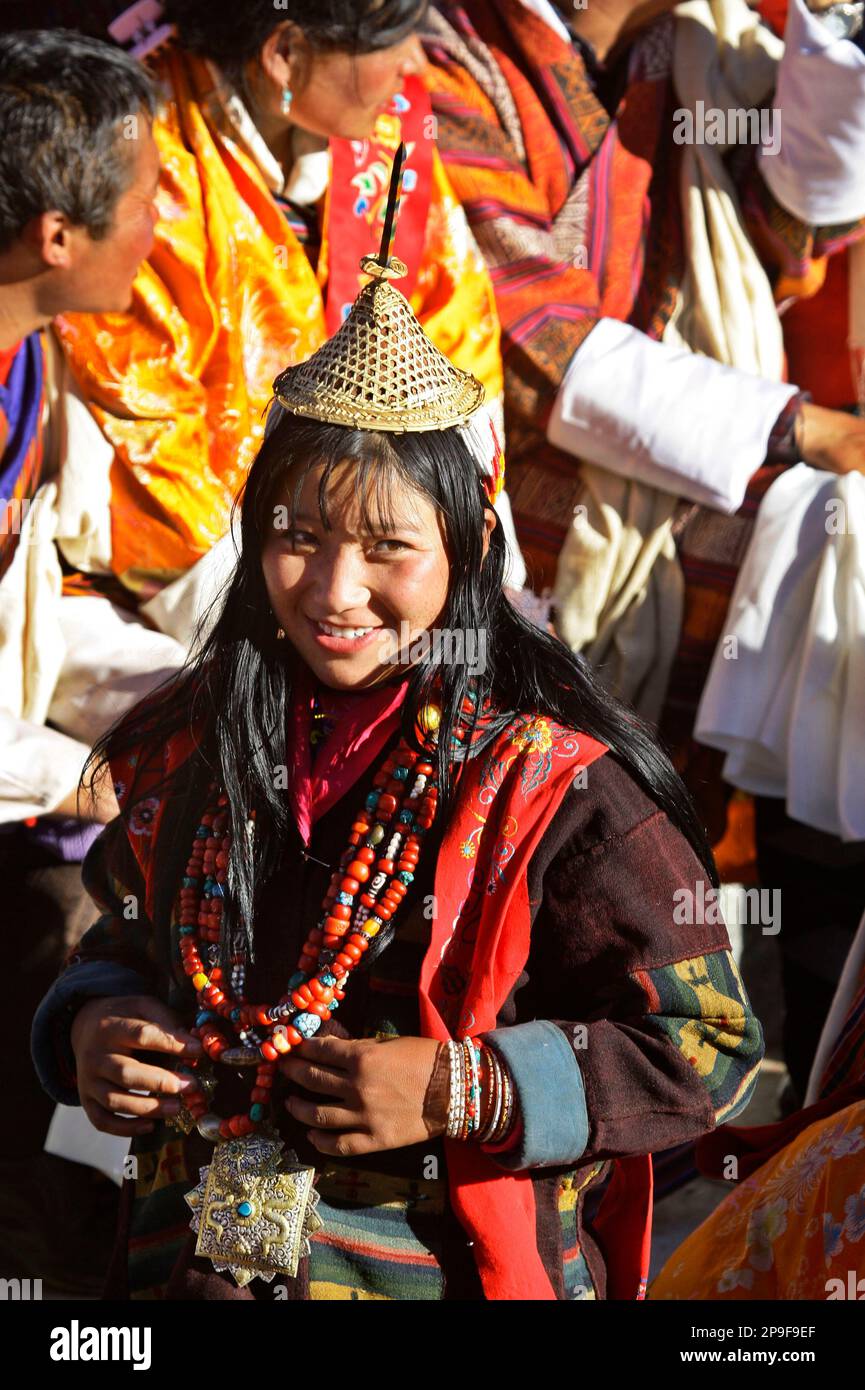 A Bhutanese woman in traditional attire smiles as she sits amongst the ...