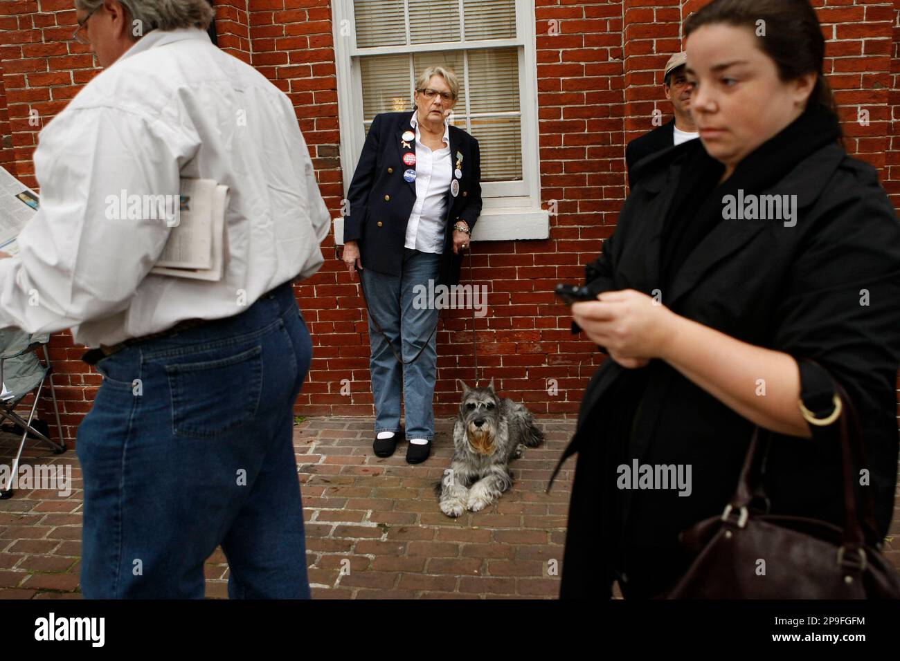 Voting precinct chairperson Hazel Rigby, and her dog 'Victor', watch as ...