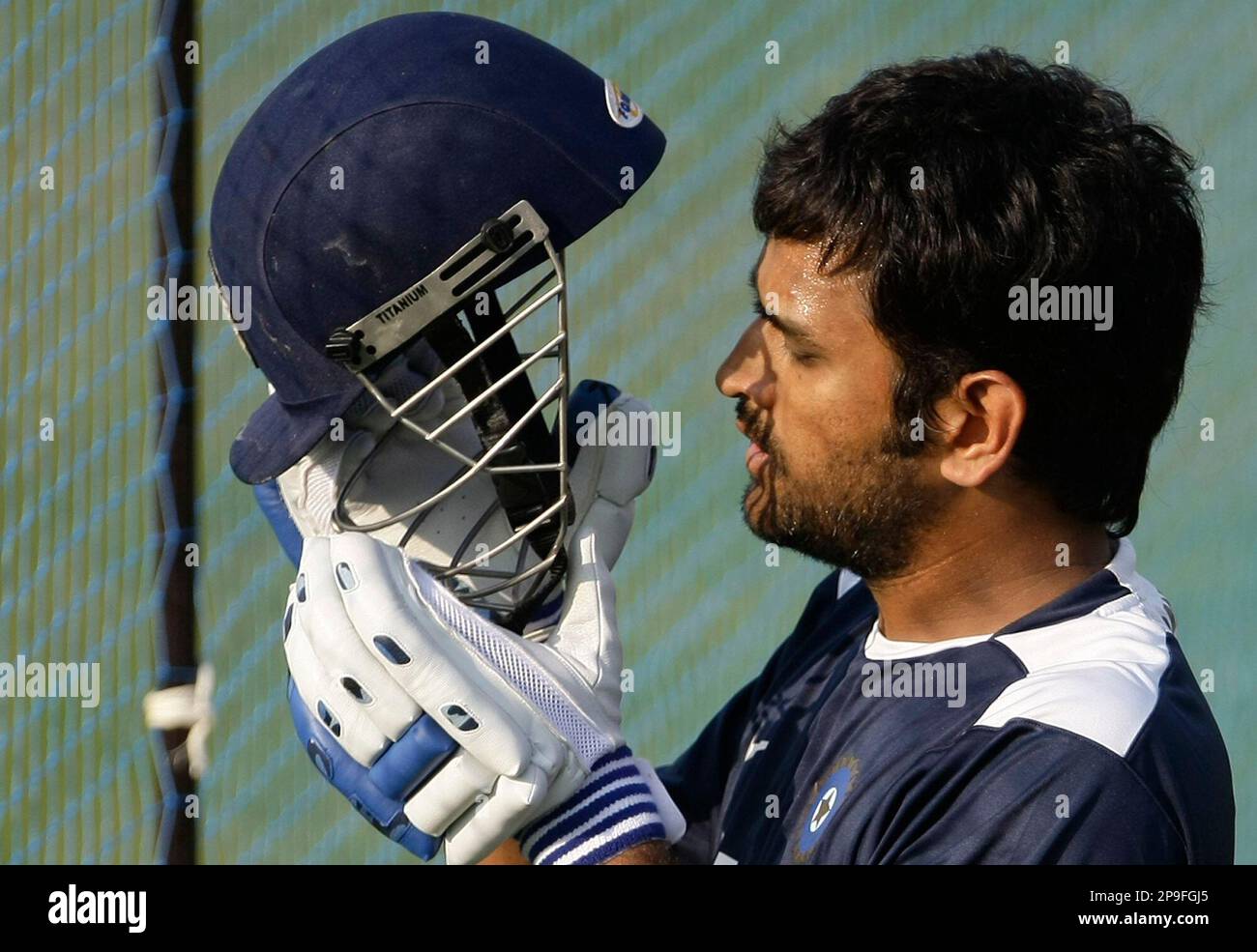 Indian cricketer Mahendra Singh Dhoni wears a helmet before a session ...