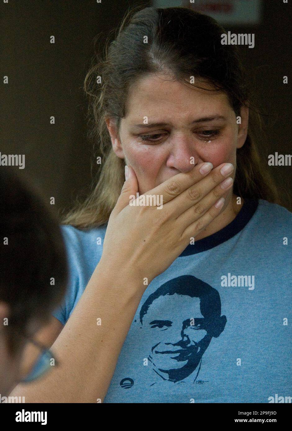 Penelope Van Tuyl of San Francisco, sheds tears after placing flowers ...