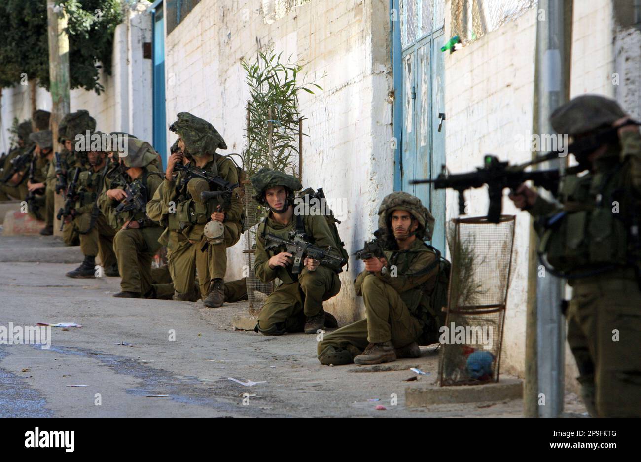 Israeli soldiers take up position during an Israeli military operation ...