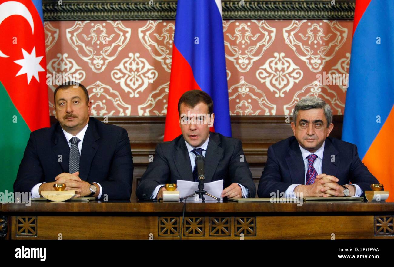 Russian President Dmitry Medvedev, center, reads a text of the ...