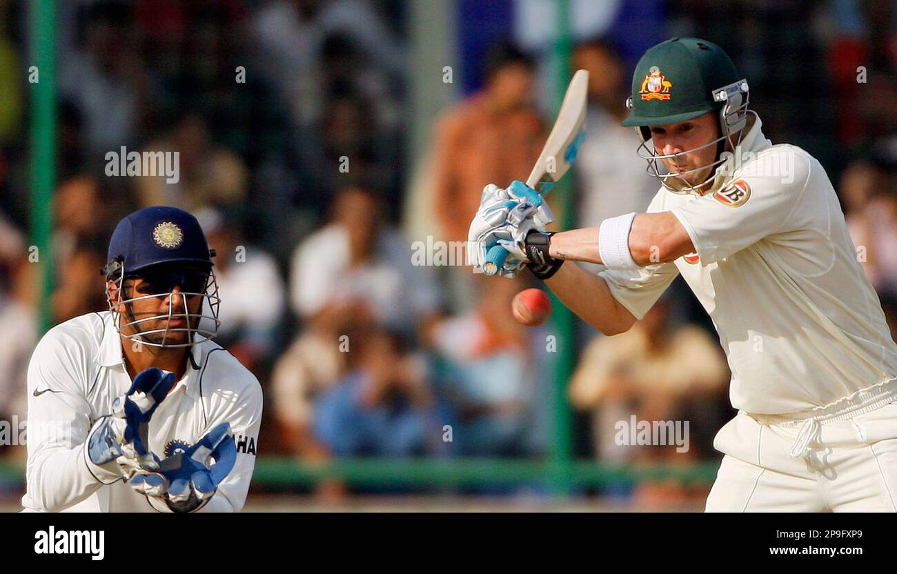 Australian cricketer Michael Clarke, right, bats as India's Mahendra ...